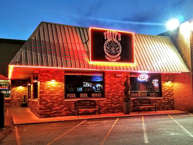 Tolly's neon sign glows like a culinary lighthouse in the night, beckoning hungry travelers with promises of pizza, beer, and wings.
