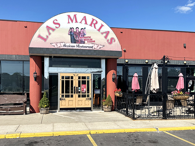 Sunshine highlights the terra-cotta exterior and inviting patio space, where pink umbrellas stand ready for al fresco dining adventures.