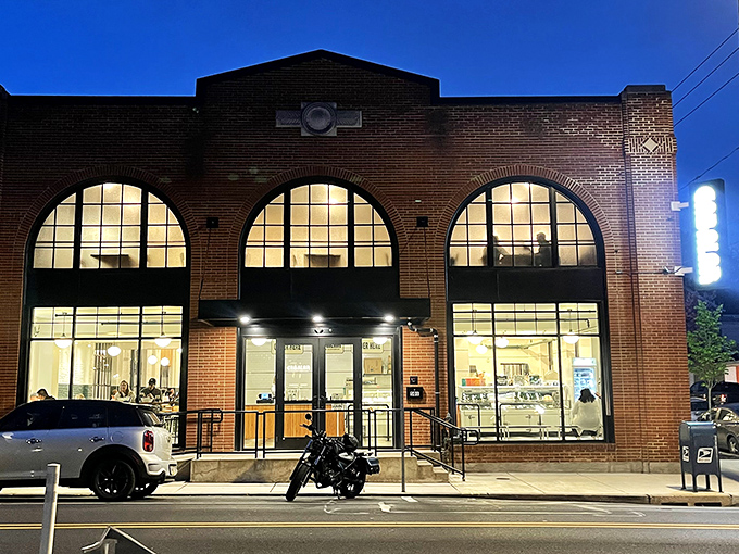 The brick fortress of flavor stands sentinel at dusk, its arched windows glowing with promise of meaty treasures within.
