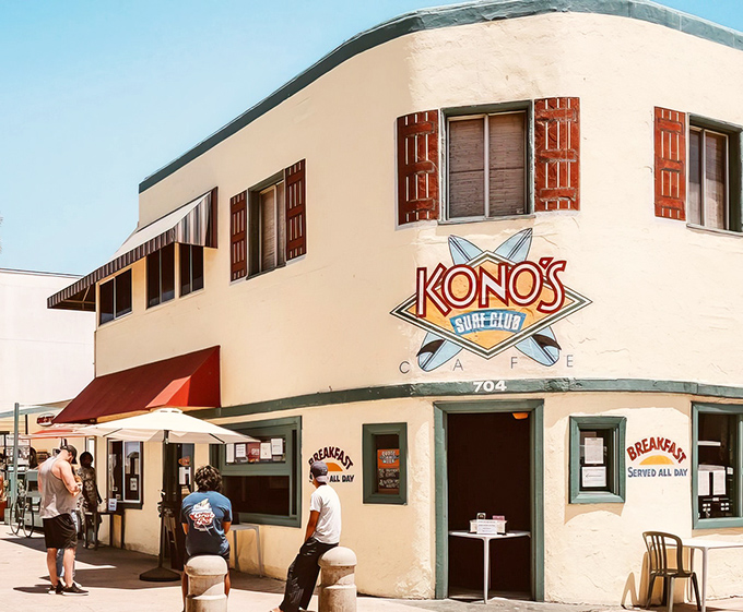 The iconic white-washed corner of Kono's stands like a beacon for breakfast pilgrims, with palm trees and seagulls completing the quintessential San Diego scene.