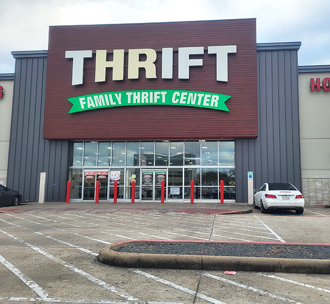 The brown and gray facade of Family Thrift Center stands like a temple to bargain hunters, its green banner promising treasures within.