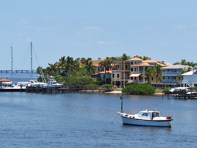 A solitary fishing boat bobs gently in Cortez's crystal waters, perfectly framed by waterfront homes that whisper "Old Florida" charm.