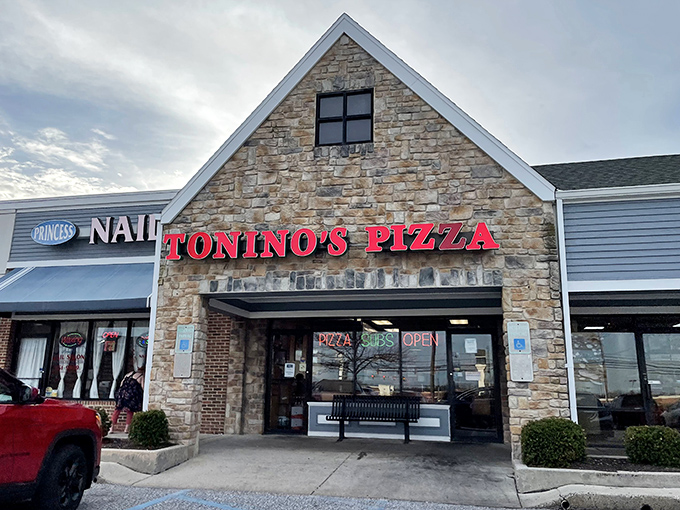 The stone facade of Tonino's Pizza stands like a culinary lighthouse on Jonestown Road, beckoning hungry travelers with its bold red signage.