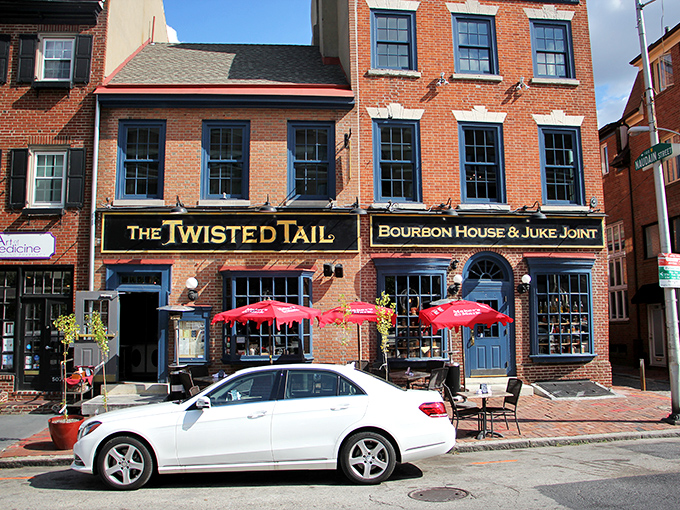 The historic brick facade of The Twisted Tail stands proudly on South 2nd Street, its red umbrellas beckoning like culinary semaphores in Philadelphia's Society Hill.