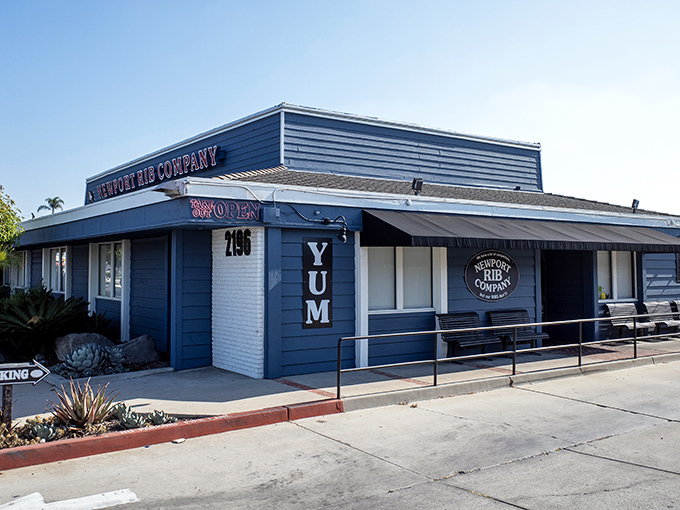 The unassuming blue exterior of Newport Rib Company hides a barbecue paradise within. That "YUM" sign isn't just decoration&mdash;it's truth in advertising.