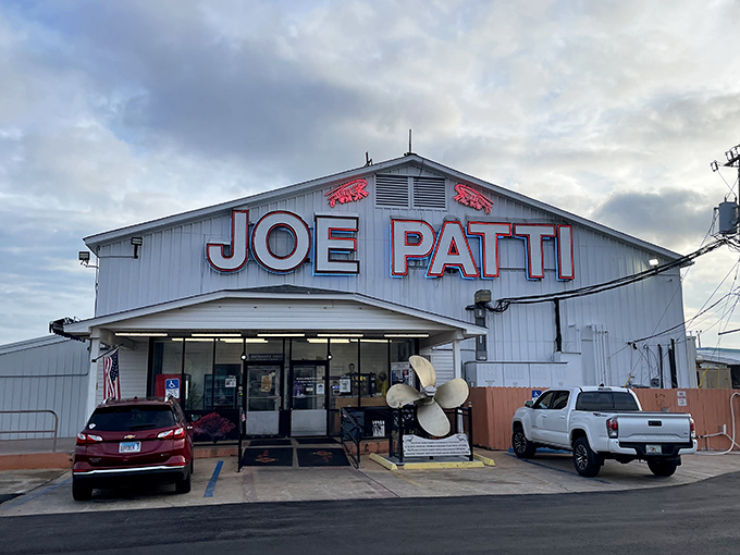 The iconic white building with bold red lettering announces your arrival at seafood paradise. No fancy frills needed when the goods inside speak for themselves.