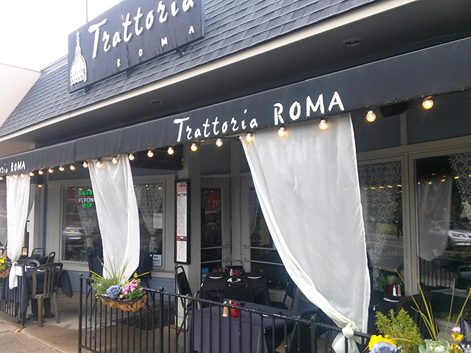 The warm glow of Trattoria Roma beckons from Grandview Avenue, its sheer curtains offering glimpses of Italian magic happening inside.