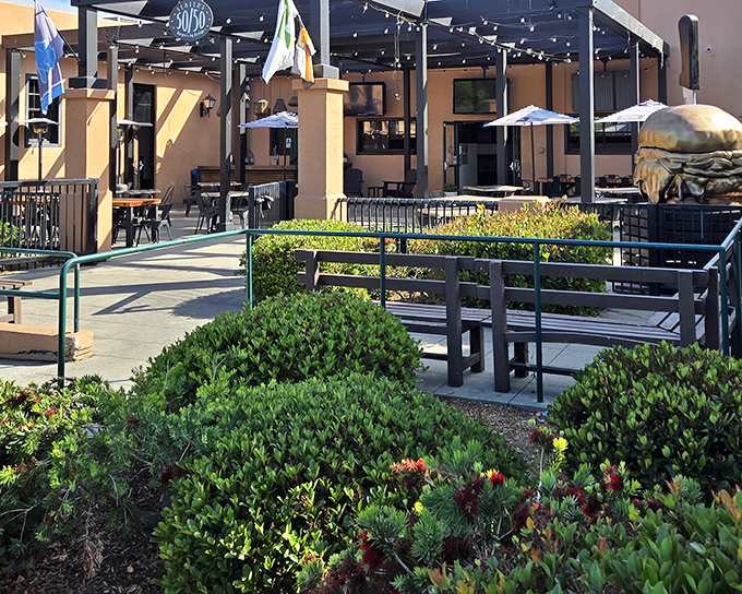 Sunshine, string lights, and the promise of burger bliss – Slater's 50/50's inviting patio beckons with casual charm and a giant burger sculpture that's basically a preview of coming attractions.