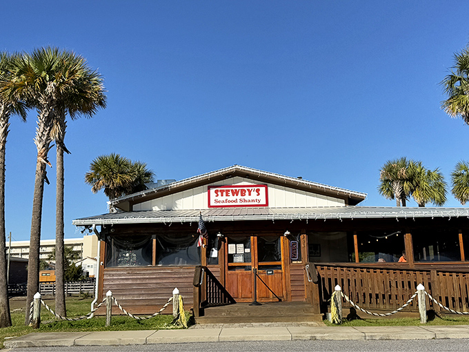 Stewby's Seafood Shanty stands like a beacon of Old Florida charm, palm trees standing guard over this unassuming treasure that promises seafood nirvana.