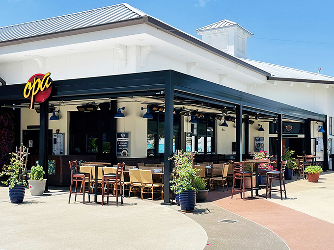 The inviting exterior of Taverna Opa beckons with its crisp white walls and signature blue accents, promising Mediterranean delights just steps away from Orlando's tourist hustle.