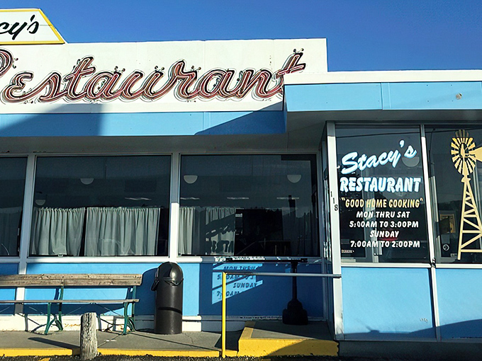 The iconic blue-trimmed exterior of Stacy's Restaurant stands like a beacon of breakfast hope against the Kansas sky. Good home cooking awaits inside!