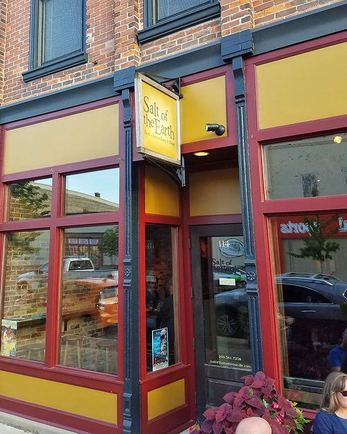 The bright yellow and burgundy facade of Salt of the Earth stands like a beacon of culinary promise on Fennville's Main Street, inviting hungry travelers to step inside.