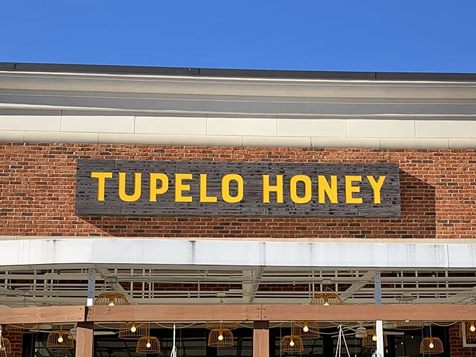 The bright yellow Tupelo Honey sign against rustic brick is like a beacon calling to hungry souls across Asheville.