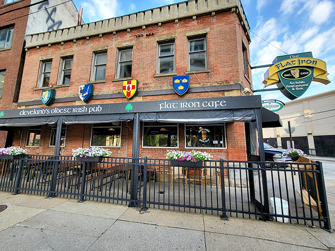 The triangular brick building housing Flat Iron Cafe stands proudly in Cleveland's Flats district, its heraldic shields announcing its Irish heritage like medieval banners.