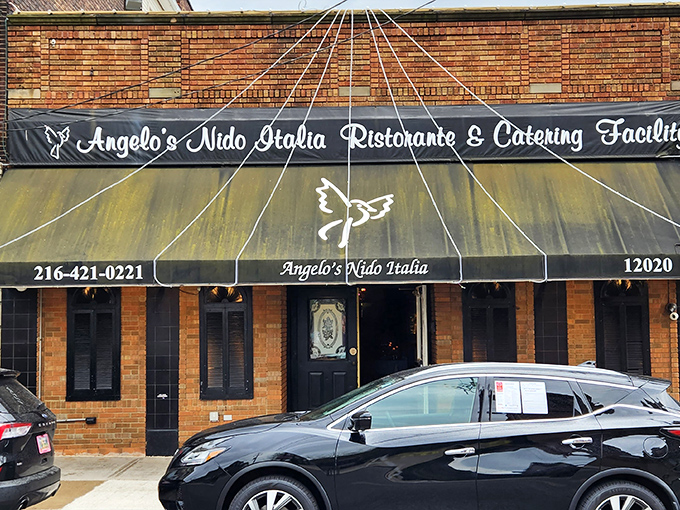 The unassuming brick exterior of Angelo's Nido Italia beckons like an old friend, promising culinary treasures behind its classic awning and modest fa&ccedil;ade.