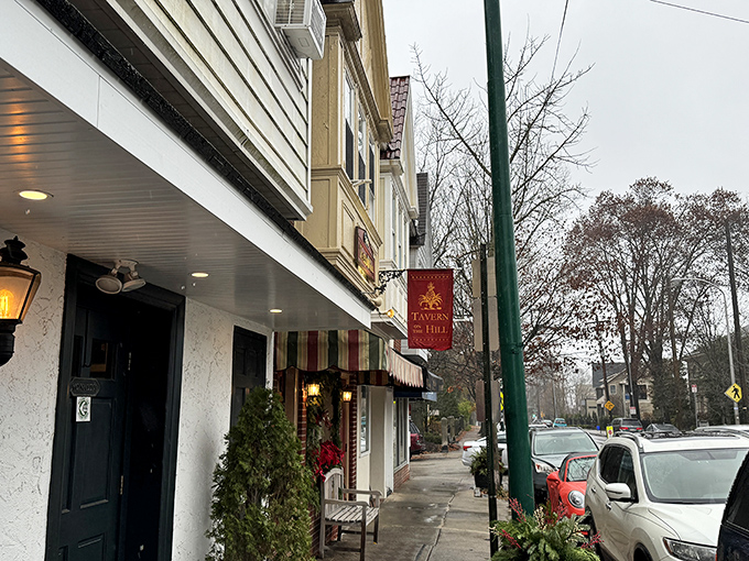 The unassuming storefront of McNally's Tavern, where culinary legends are born behind that modest red banner and classic striped awning.