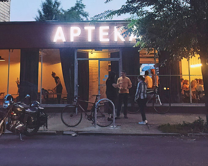 As evening falls, Apteka's illuminated sign becomes a beacon for hungry cyclists and food adventurers seeking Eastern European comfort without the meat sweats.