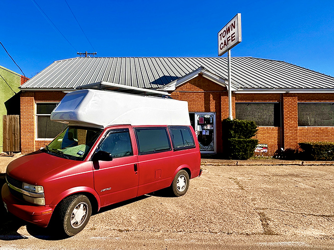 Another angle reveals the humble charm of Town Cafe, where that red van might just belong to someone who drove 100 miles for their legendary breakfast.
