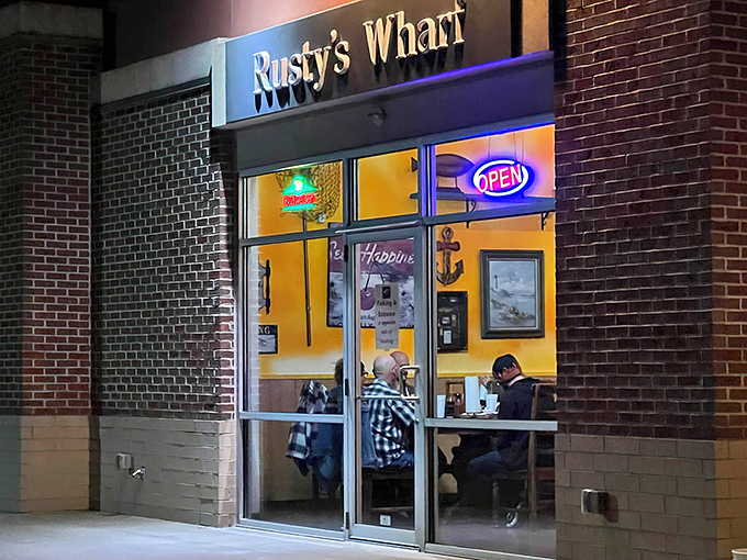 The neon "OPEN" sign beckons like a lighthouse to hungry travelers. Rusty's Wharf's bright yellow interior promises warmth even on the chilliest Ohio evening.