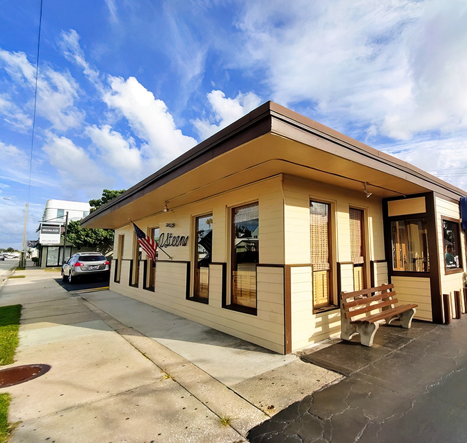 The American flag waves a patriotic hello outside O'Steen's, where the simple script signage promises authentic coastal dining without pretension.