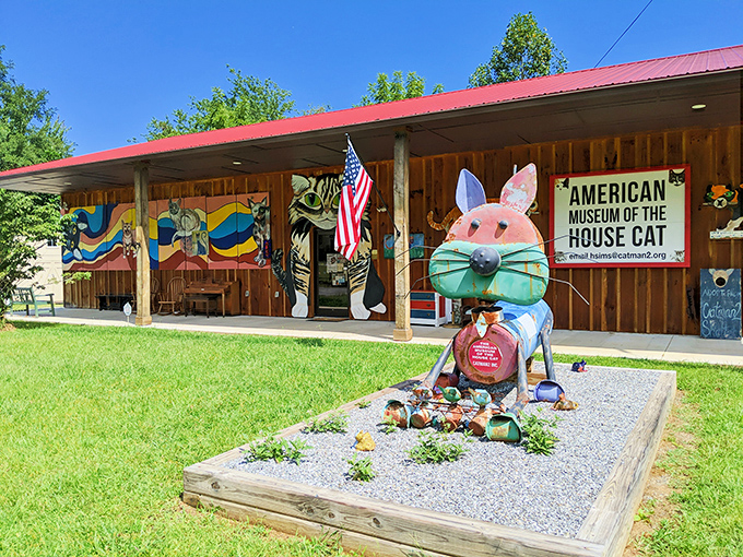 The American Museum of the House Cat welcomes visitors with rustic charm and whimsical feline sculptures that hint at the treasures waiting inside.