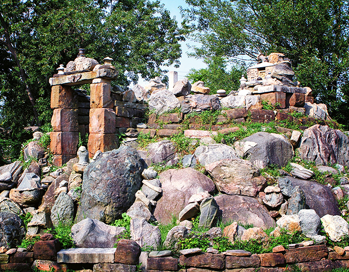 Stone archways reach skyward like ancient portals to another realm. Nature and human creativity collaborate in this backyard masterpiece.