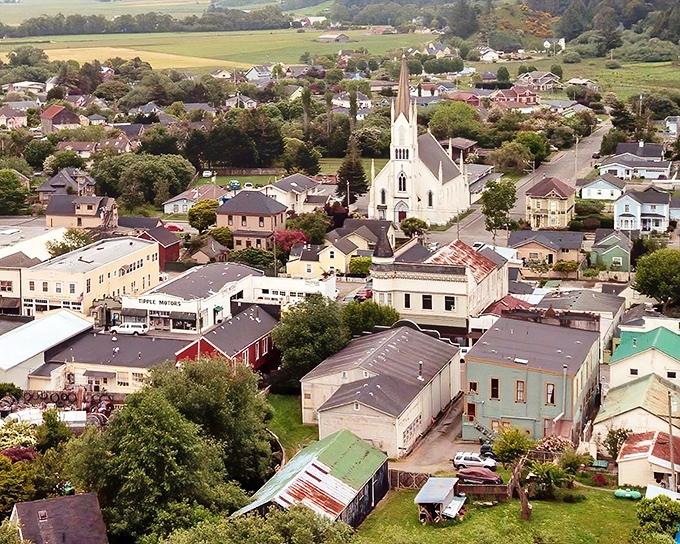 The white church spire rises above Ferndale's compact downtown, surrounded by a patchwork of colorful rooftops and verdant gardens.