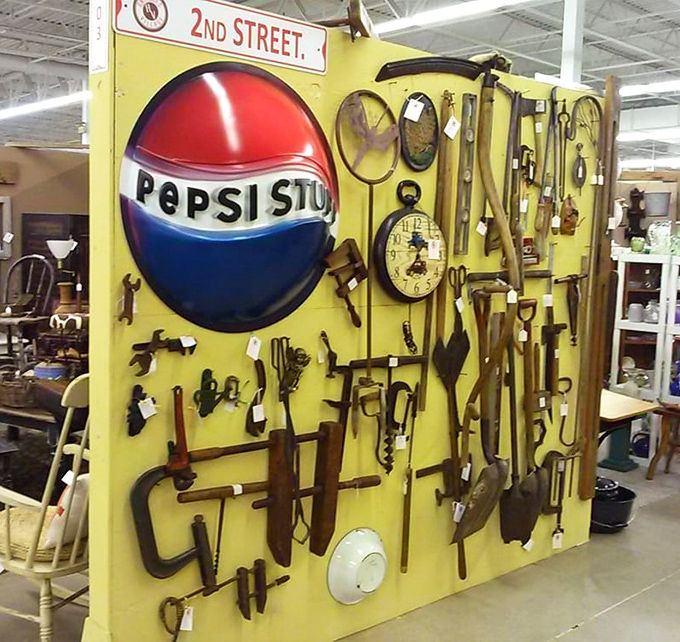Tools that built America hang like industrial art on this display wall. That Pepsi sign? The perfect complement to a workshop of memories.