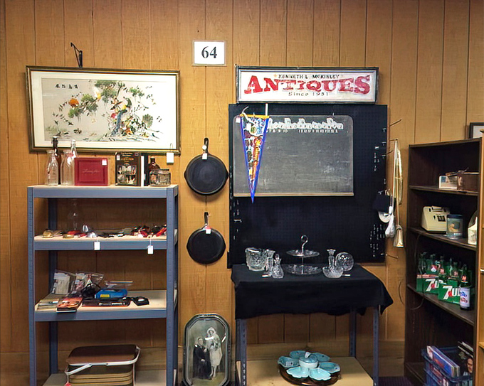 Booth 64 showcases the beautiful chaos of collecting. That chalkboard probably taught multiplication tables to kids now collecting Social Security.