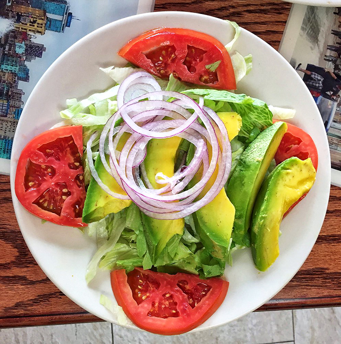 The avocado salad arrives like edible art, fresh and vibrant enough to make your cardiologist smile.