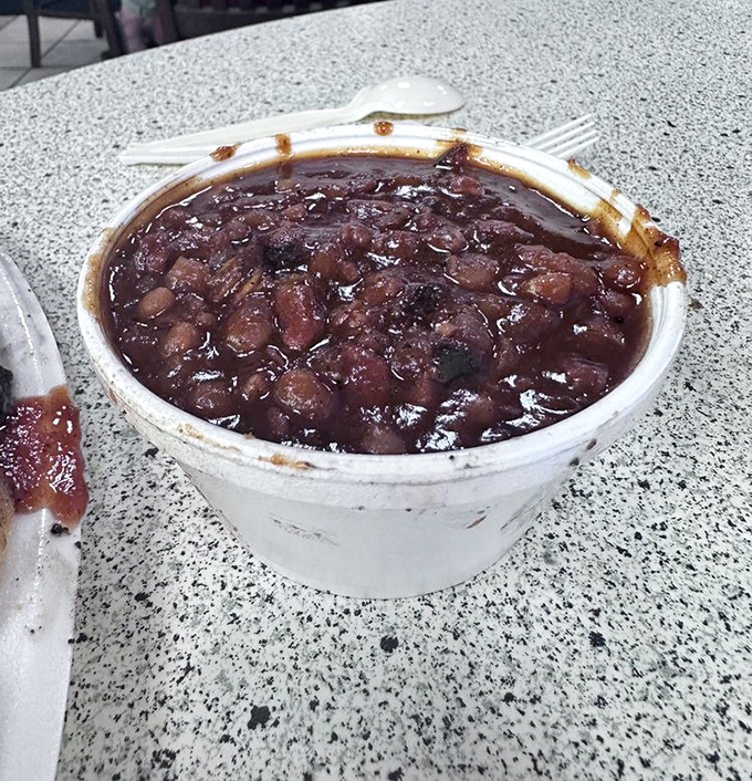 BBQ beans that have clearly been fraternizing with smoked meat. This isn't side dish territory; it's a supporting actor worthy of awards.