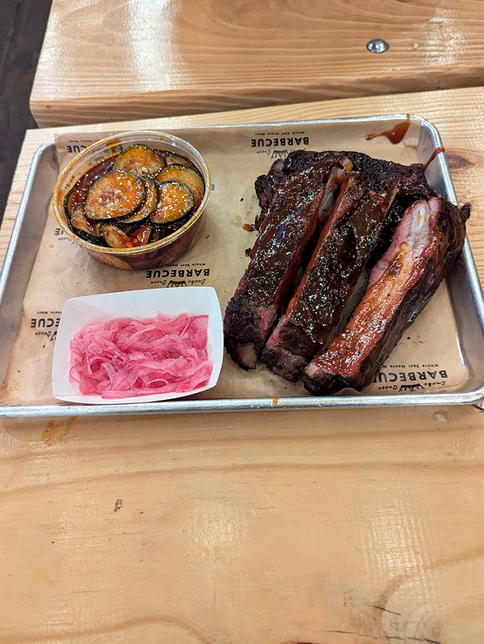 Ribs with a bark so beautiful they belong in an art gallery. That pink pickled garnish adds the perfect acidic counterpoint.