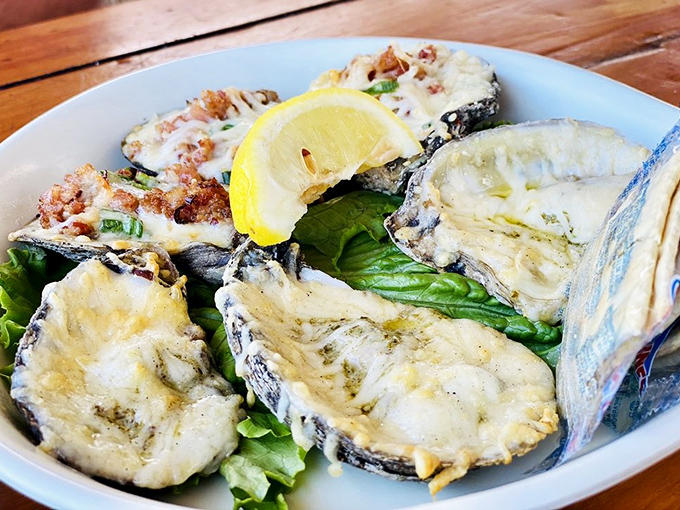 Baked oysters resting on a bed of greens with a bright lemon accent &ndash; nature's perfect appetizer getting the respect it deserves.