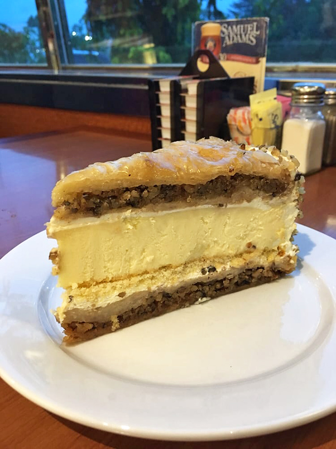 A slice of baklava cheesecake that's having an identity crisis in the most delicious way possible &ndash; honey, nuts, and creamy decadence.