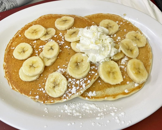 Banana pancakes with a cloud of whipped cream&mdash;proof that sometimes the simplest pleasures are just a spatula flip away from perfection.
