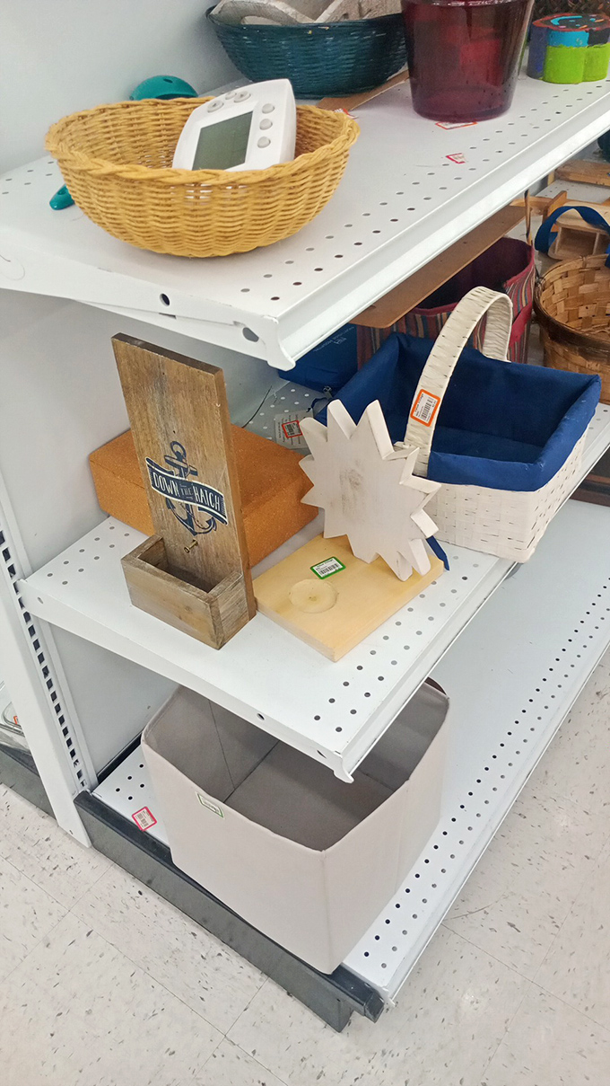 Home d&eacute;cor treasures nestled on metal shelving. That wicker basket once held someone's knitting&mdash;now it awaits your remote controls.