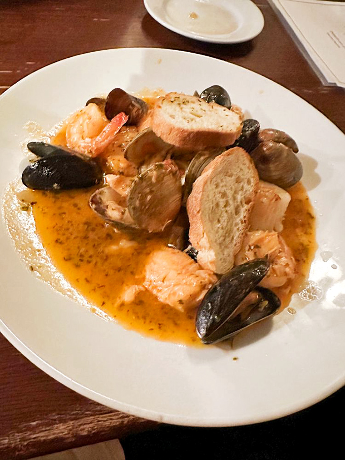 Seafood swimming in a saffron-kissed broth with crusty bread for sopping. The kind of dish that transports you to coastal France without the airfare.