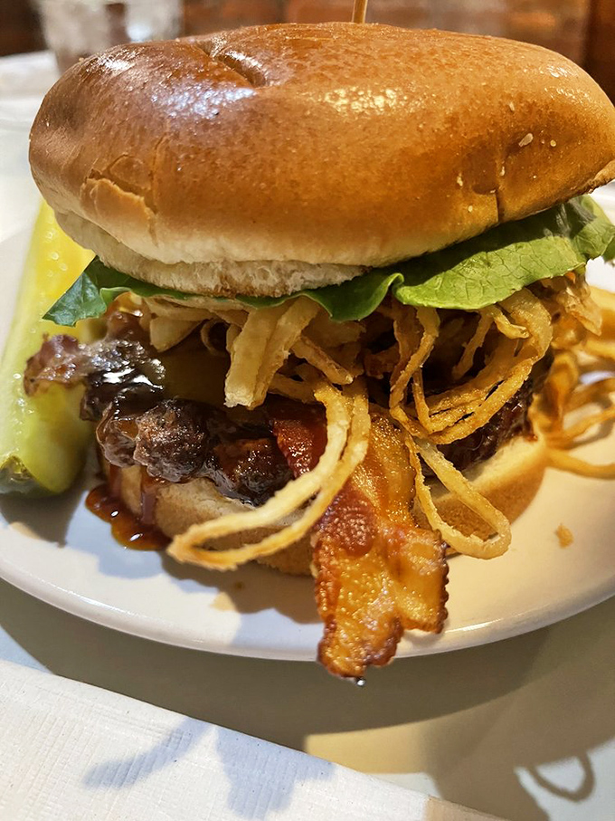A burger that doesn't need a fancy pedigree to impress, just perfectly cooked beef, crispy bacon, and enough toppings to require a strategic eating plan.