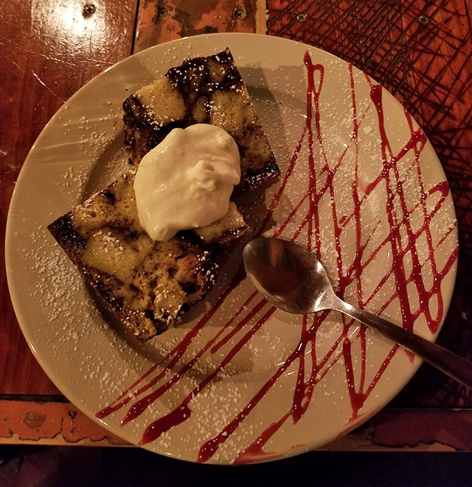 Bread pudding that makes you question why you've wasted time on lesser desserts, artfully presented with a raspberry drizzle dance.