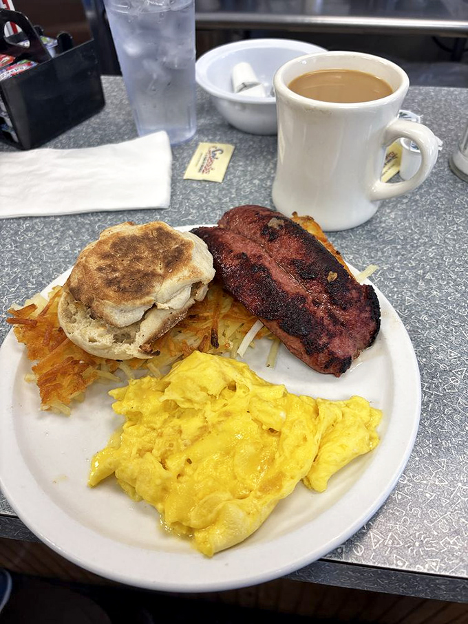 The full breakfast experience: scrambled eggs, bacon, and hash browns arranged like a morning symphony.