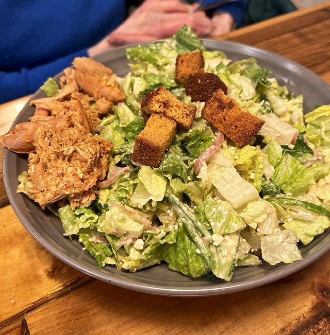 Even the Caesar salad gets the barbecue treatment, proving that sometimes lettuce is just a vehicle for more smoked meat.