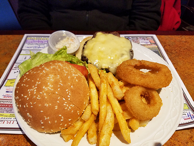 The classic American trifecta: a perfectly grilled burger, golden fries, and crispy onion rings&mdash;comfort food that speaks a universal language.