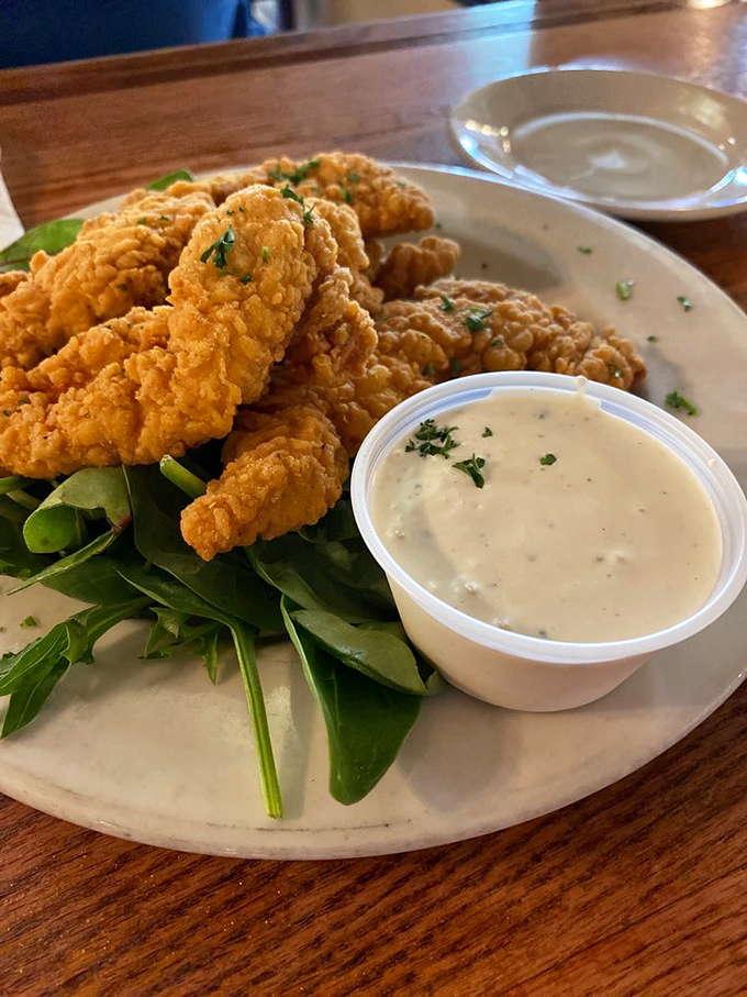 Golden-fried chicken tenders that put fast food versions to shame, served with house-made dipping sauce and a bed of fresh greens.