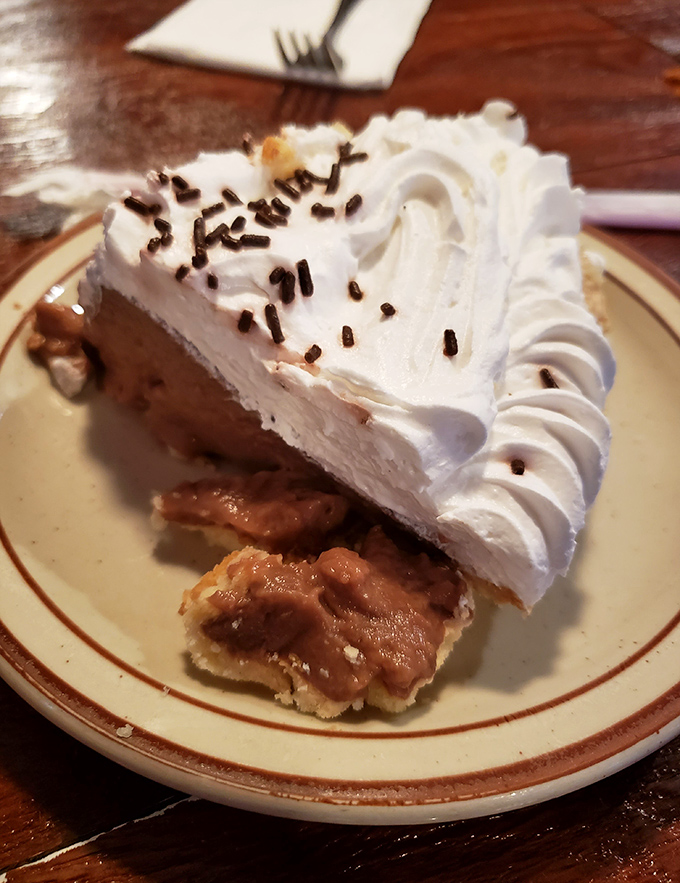 A slice of chocolate cream pie with a cloud of whipped topping that makes you wonder why you ever considered ordering anything else.