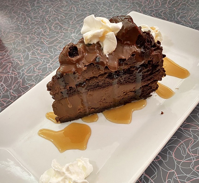 A slice of chocolate cake so decadent it should require a permission slip, drizzled with caramel that forms delicious puddles of joy.