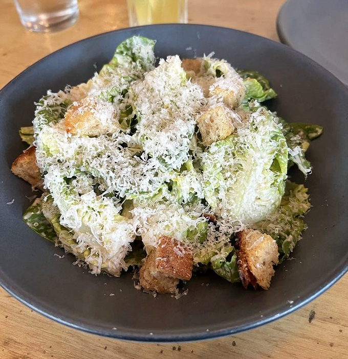 A Caesar salad that Julius himself would approve &ndash; crisp romaine baptized in parmesan snowfall and punctuated with rustic croutons.