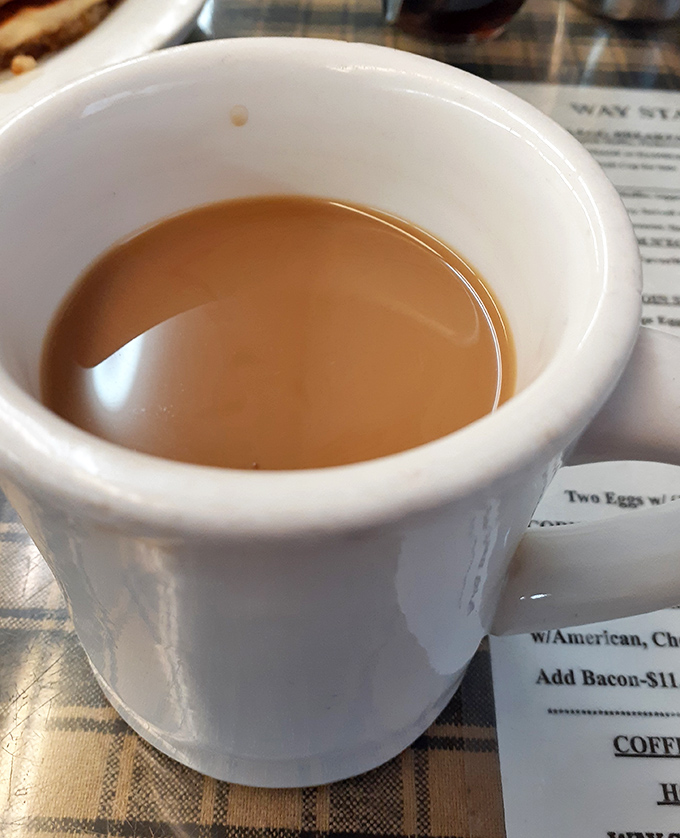 Coffee in a sturdy white mug &ndash; no pretentious vessels here. This is the kind of honest brew that fuels conversations and cures Monday mornings.