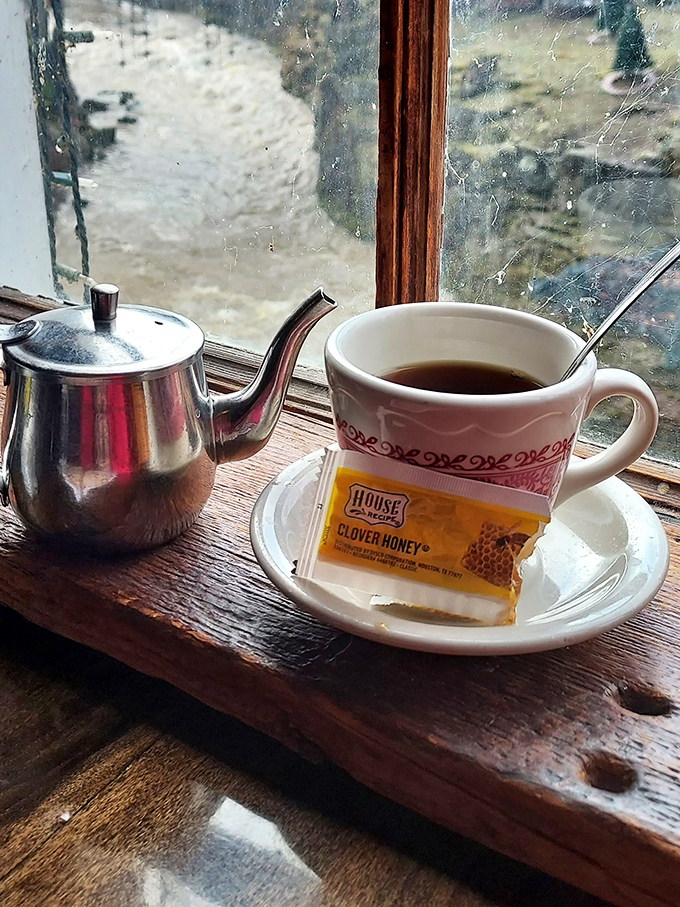 Coffee with a view—the perfect morning relationship. That silver teapot stands by like a loyal friend, ready for refill duty.