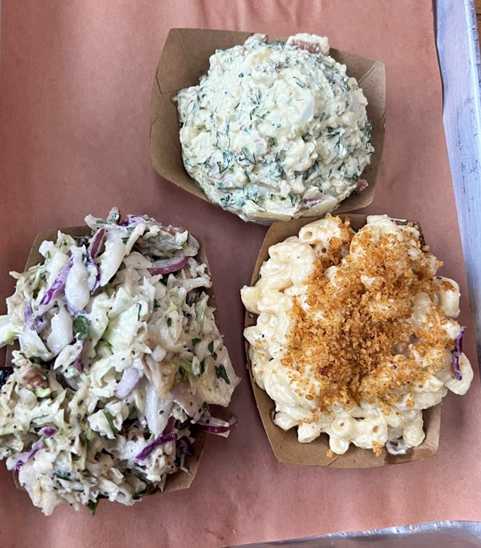 The holy trinity of barbecue sides: creamy mac and cheese, tangy slaw, and potato salad that doesn't come from anyone's aunt's recipe card &ndash; it's better.