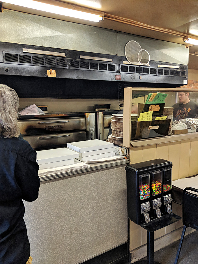 Behind this counter, pizza artisans have been crafting the same recipe for decades. No fancy wood-fired ovens&mdash;just consistent perfection.